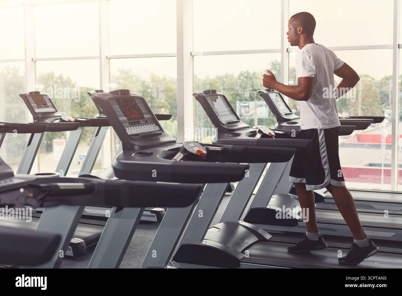 Young man in gym run on treadmill Stock Photo - Alamy