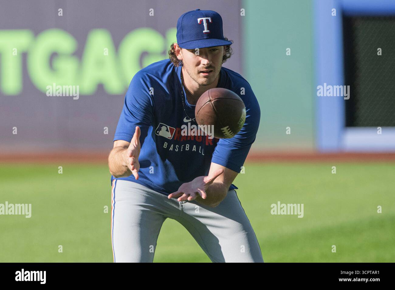 Texas Rangers relief pitcher Cole Winn catches a football before the ...