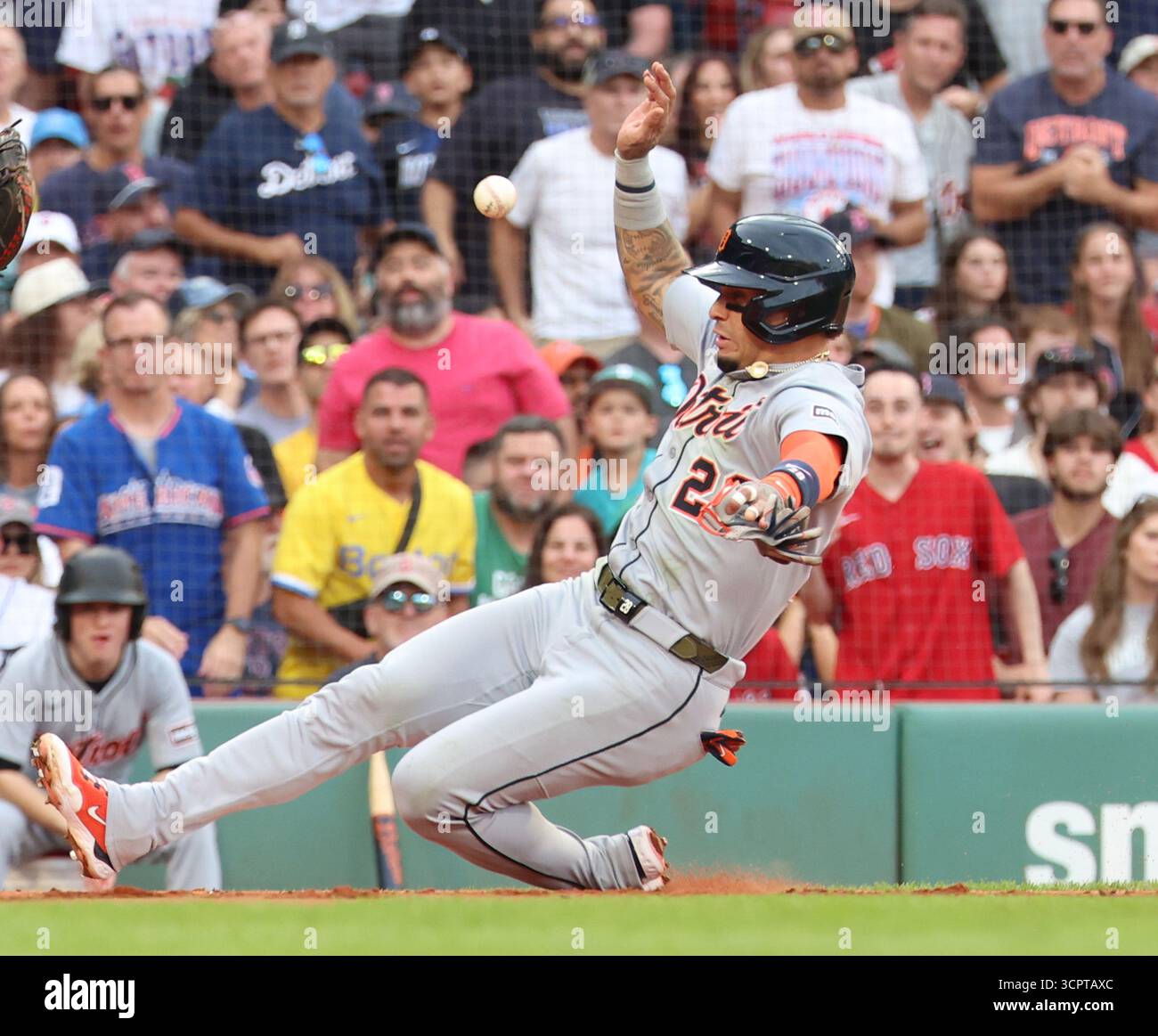 Detroit Tigers' Javier Báez slides safely into home plate ahead of a throw during the fifth ...