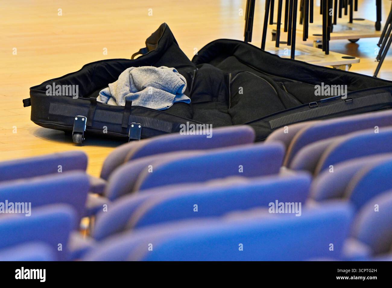 Concert stage filled with many blue folding chairs one seat lifted on ...