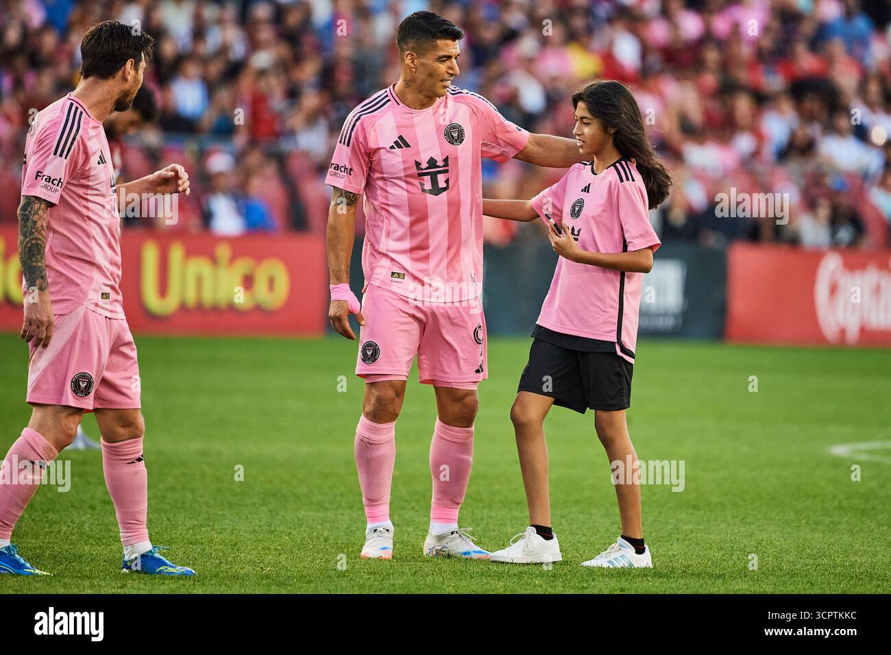 A pitch invader hugs Inter Miami's Luis Suarez (9) as Lionel Messi (10 ...