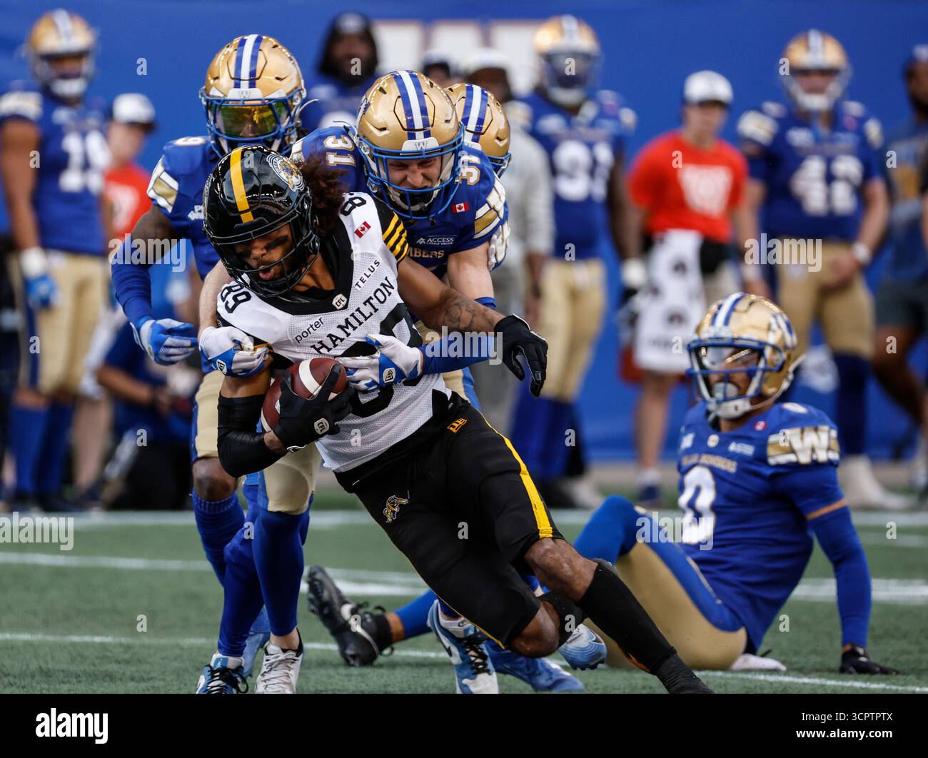 Hamilton Tiger-Cats' Kenny Lawler (89) gets tackled by Winnipeg Blue ...