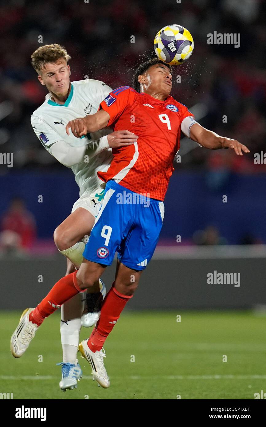 Chile's Juan Rossel, front, heads the ball next to New Zealand's James ...