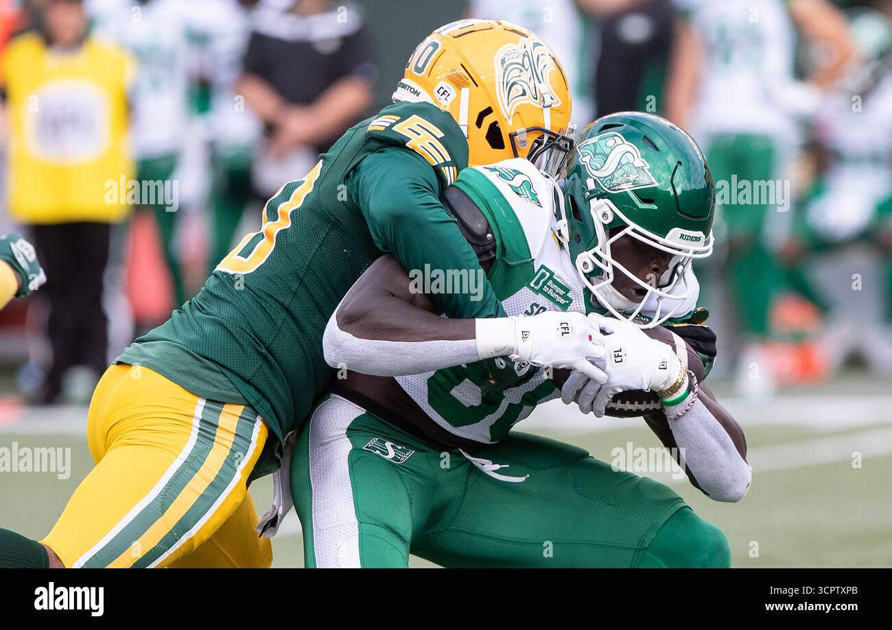 Saskatchewan Roughriders' Ajou Ajou, right, is tackled by Edmonton Elks' Tyrell Ford (30) during ...