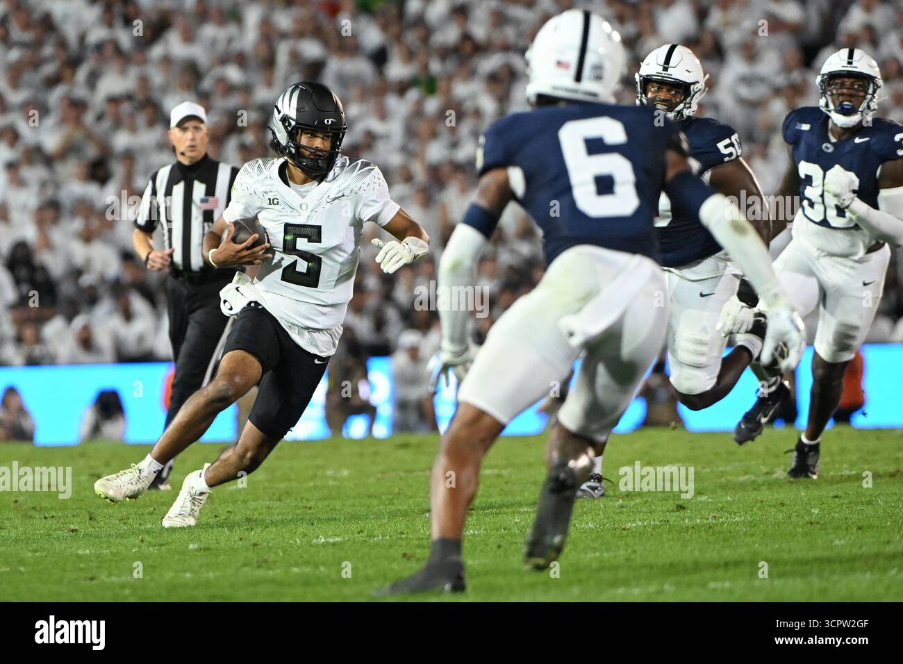 Oregon quarterback Dante Moore (5) looks to elude Penn State safety Zakee Wheatley (6) during ...
