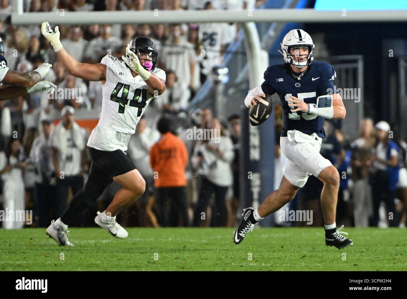 Penn State quarterback Drew Allar (15) looks to pass while being chased ...