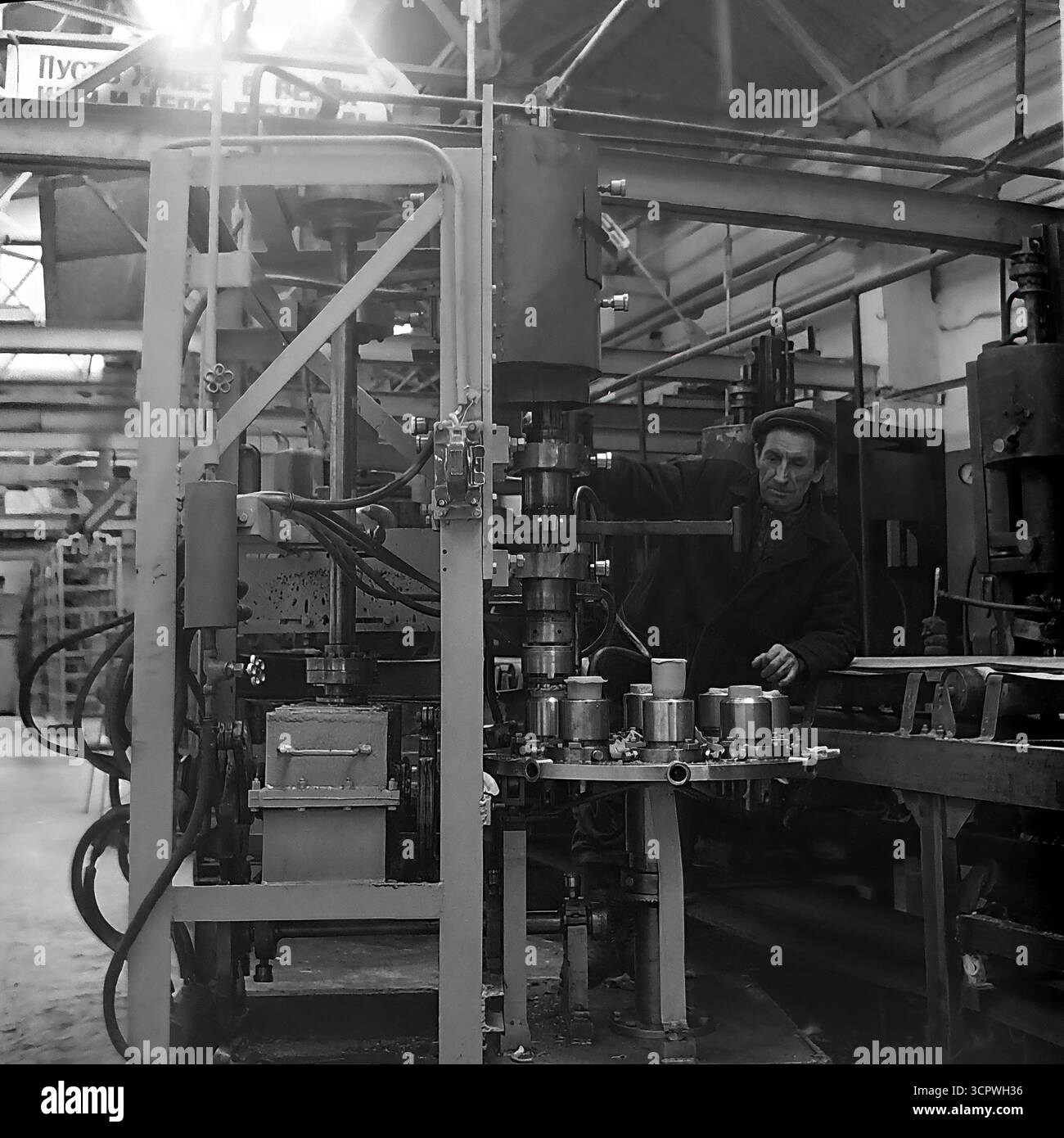 A portrait of a Soviet factory worker operating a complex industrial ...