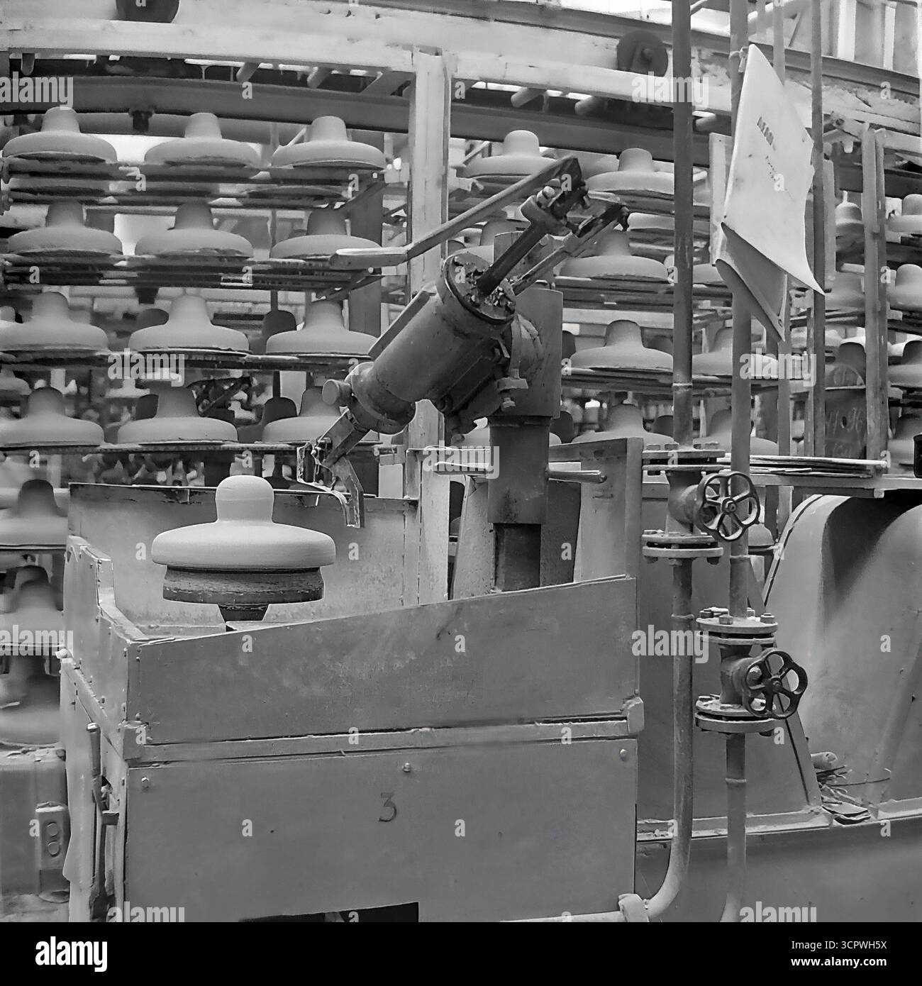 A semi-automated machine with a mechanical arm processes a large ...