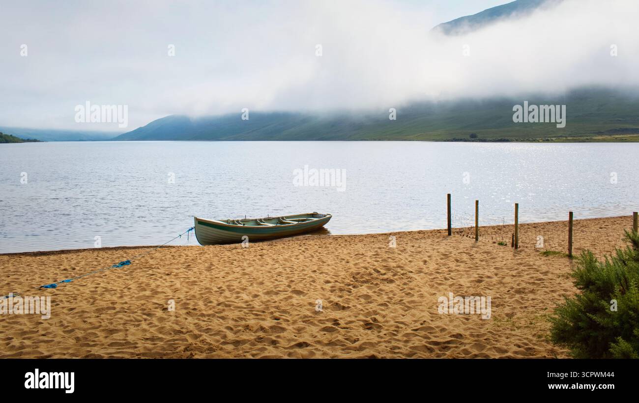 Traditional wooden boat on beach at Loch Na Fooey lake in scenic ...