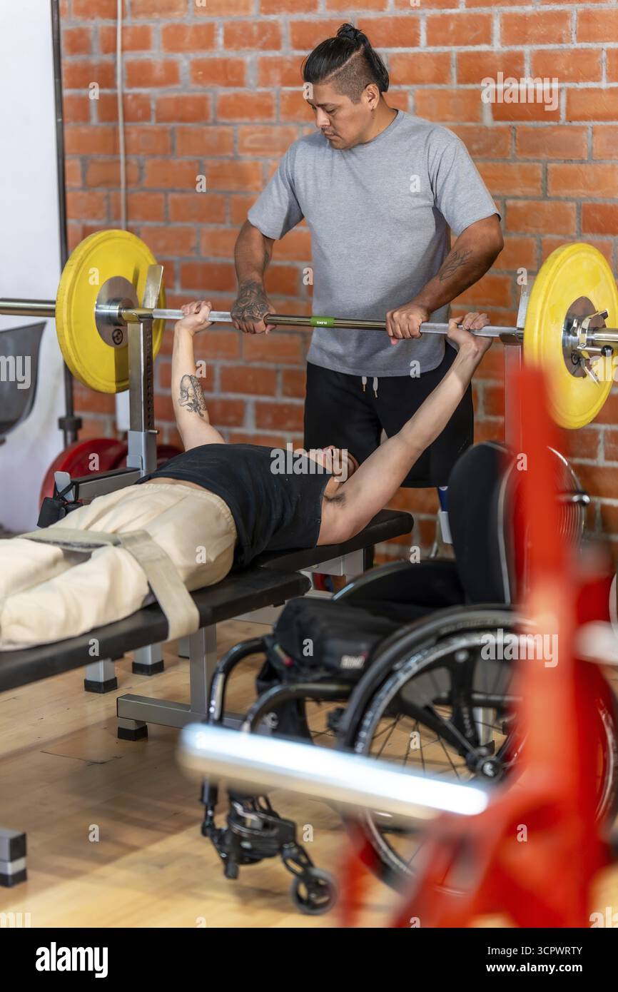 Adaptive athlete in a wheelchair performing bench press exercises with ...