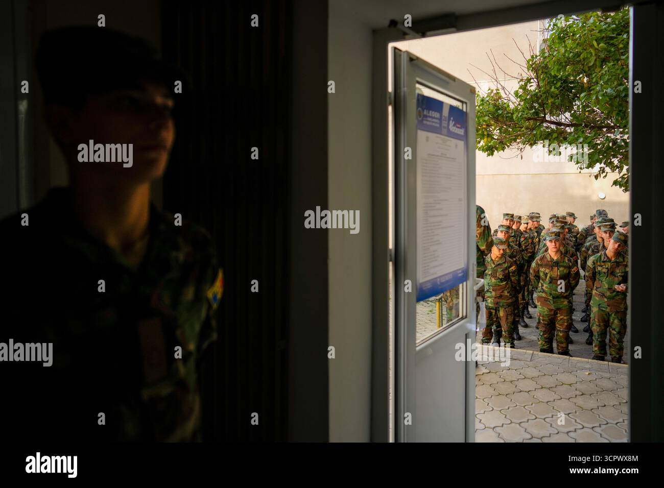 Soldiers wait outside a polling station to cast their votes during a ...