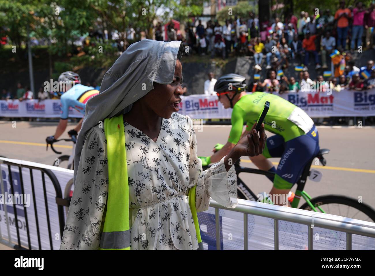 A woman takes photos of the riders passing by, during the men's Elite ...