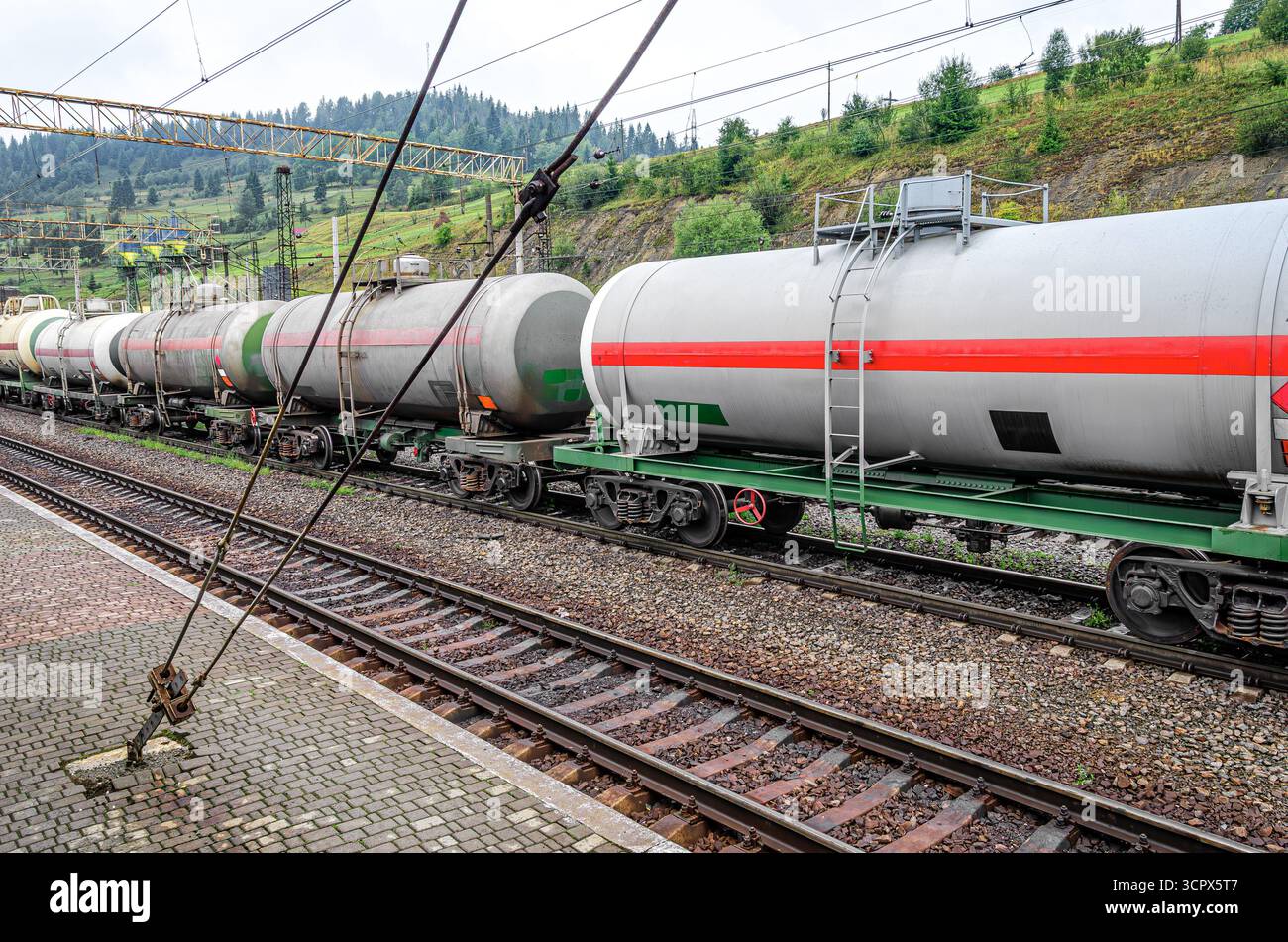Industrial freight train with tank wagons carrying liquid cargo is ...