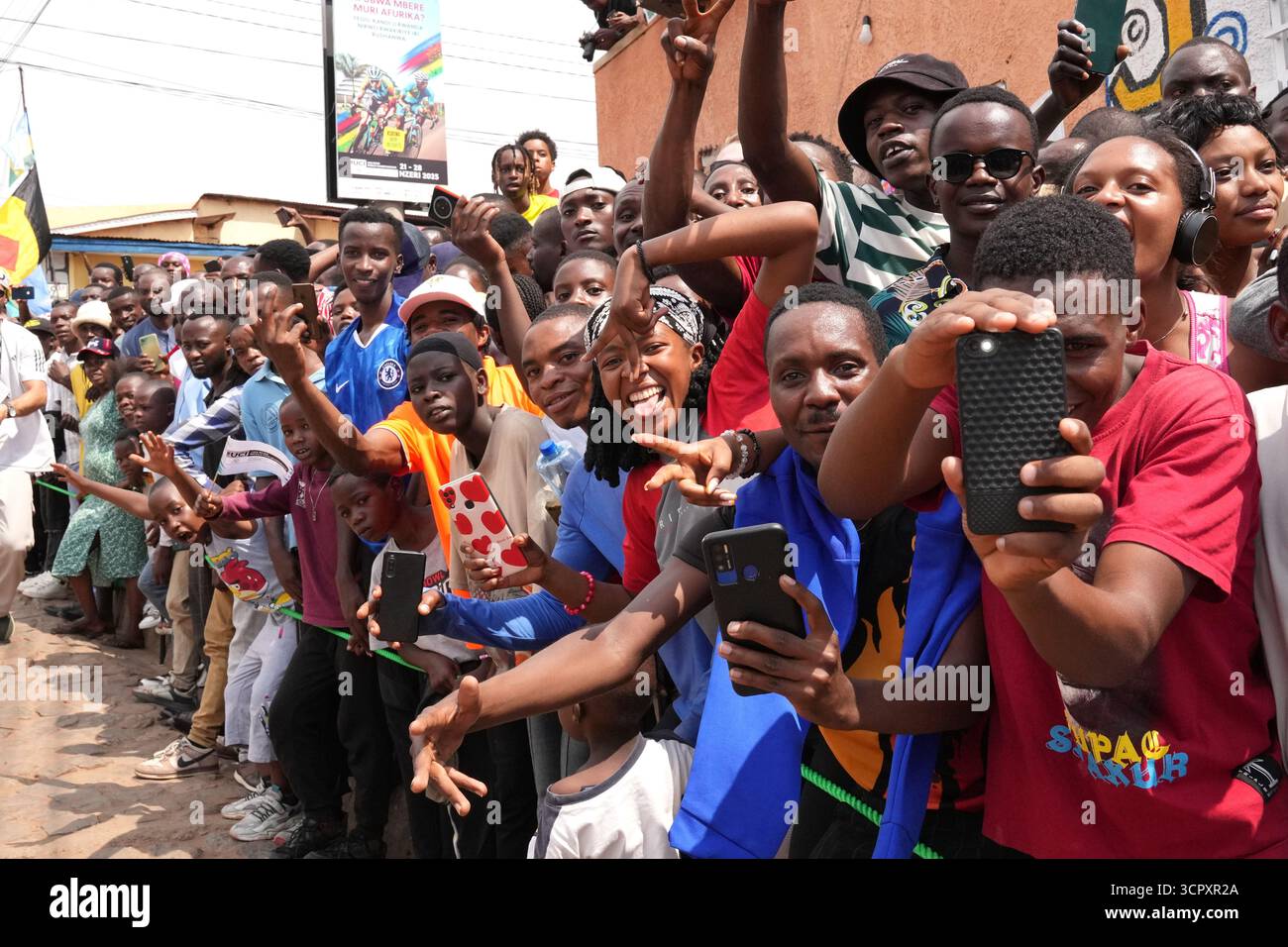 Spectators take photos and cheer during the men's Elite road race, at ...