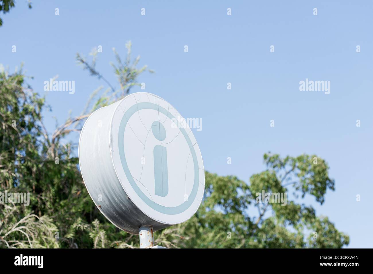 A circular information sign with a light blue 'i' symbol is mounted on ...
