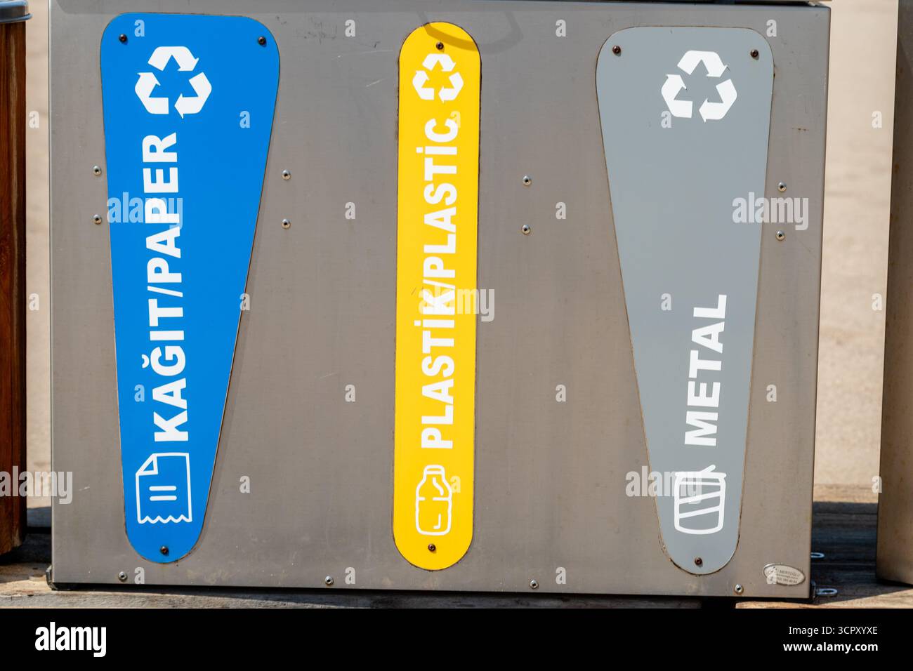 Recycling station featuring blue, yellow, and gray bins for paper ...