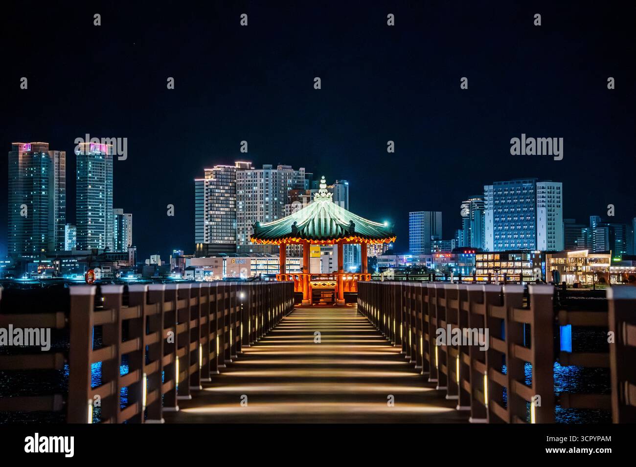 Traditional lakeside pavilion glowing at night with modern Sokcho ...