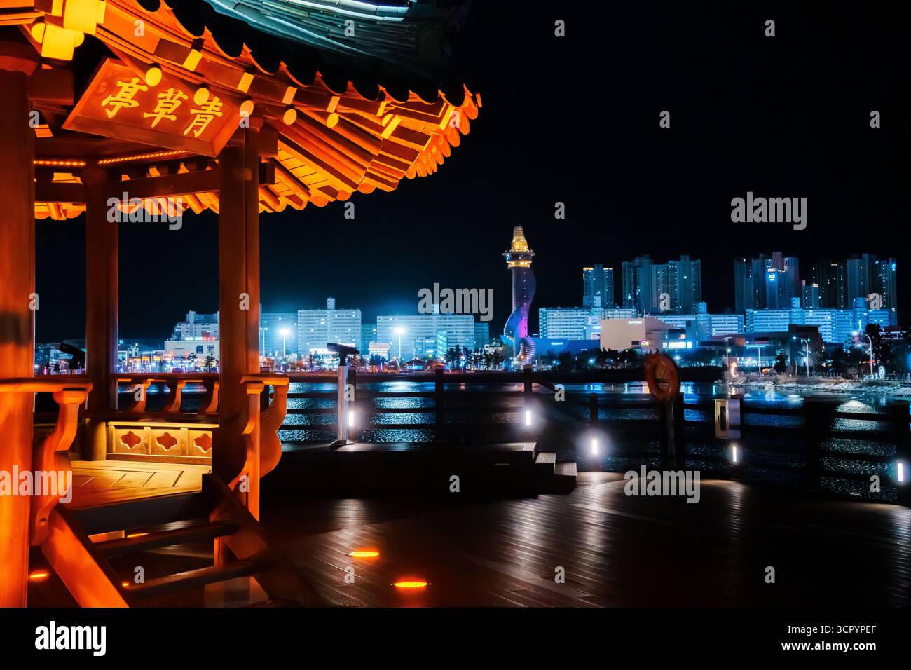 Traditional lakeside pavilion glowing at night with modern Sokcho ...
