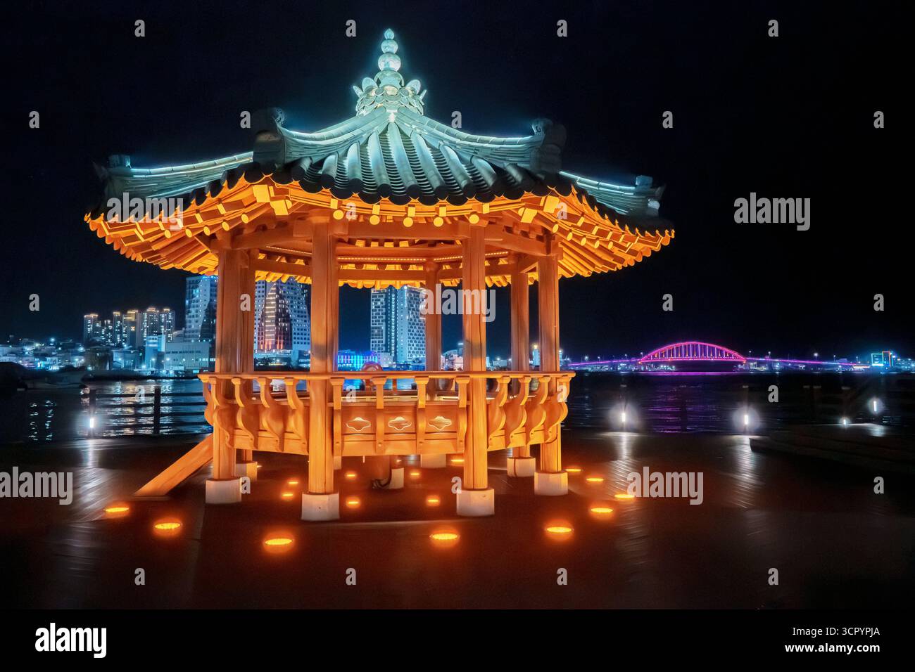 Traditional lakeside pavilion glowing at night with modern Sokcho ...
