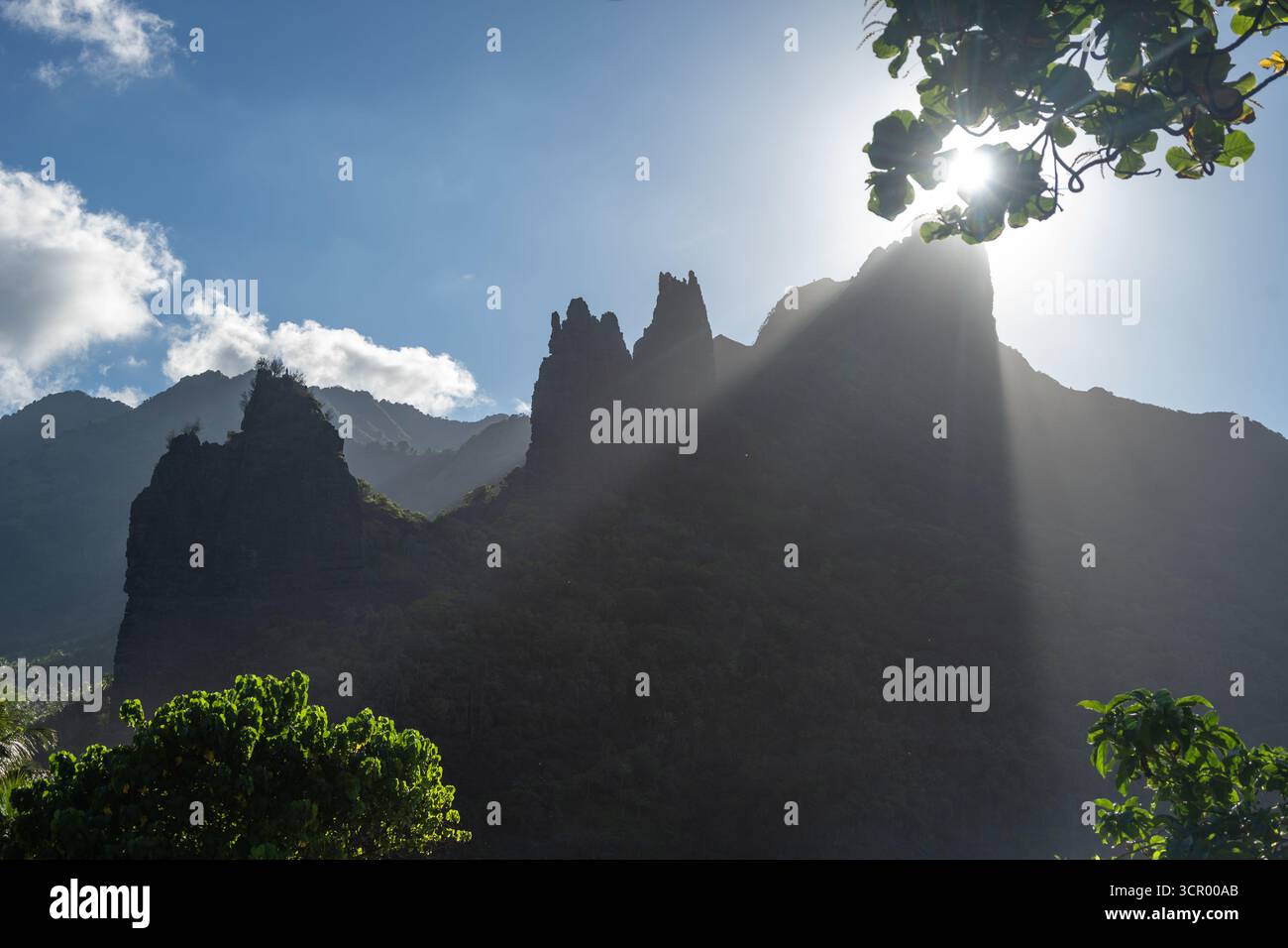 The sun sets behind jagged peaks at Hatiheu Bay, Nuku Hiva, French ...