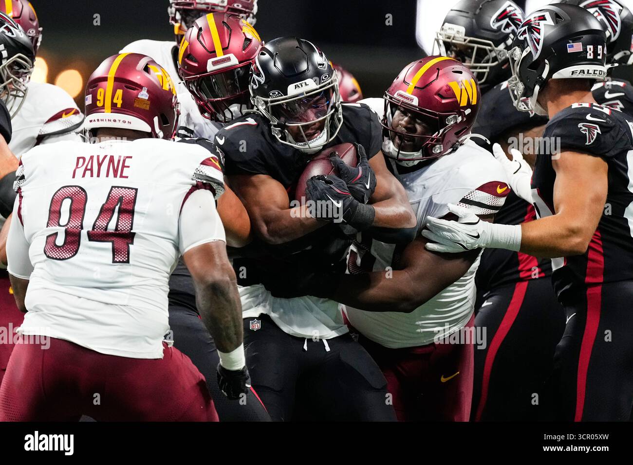 Atlanta Falcons running back Bijan Robinson, center, is tackled by a ...