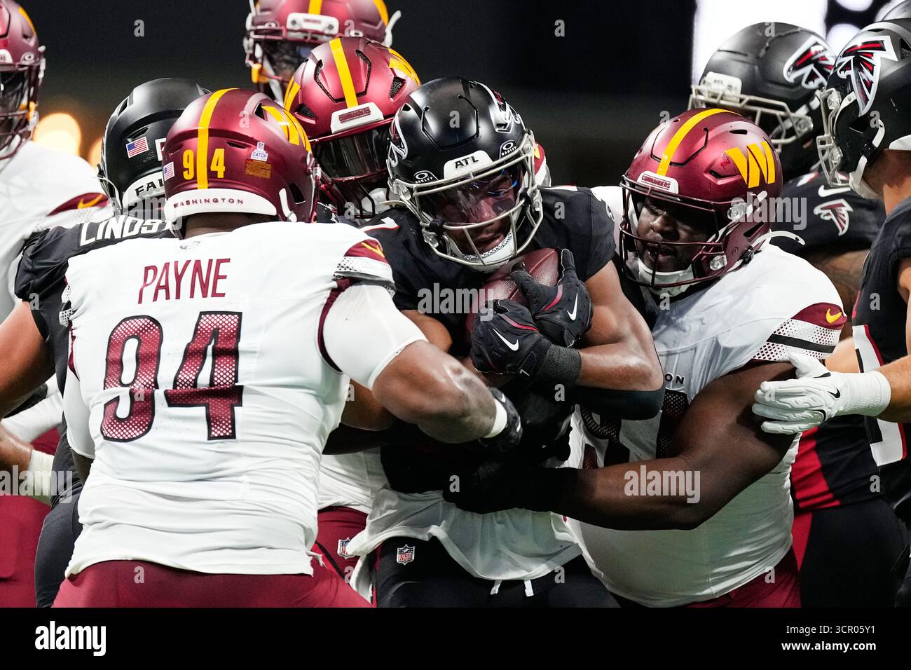 Atlanta Falcons running back Bijan Robinson, center, is tackled by a ...