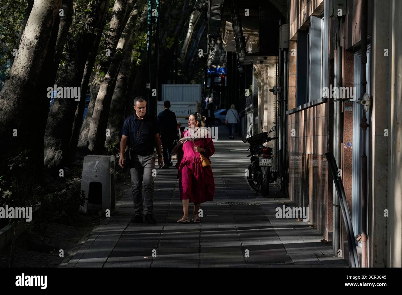 People walk on a sidewalk in northern Tehran, Iran, Sunday, Sept. 28 ...