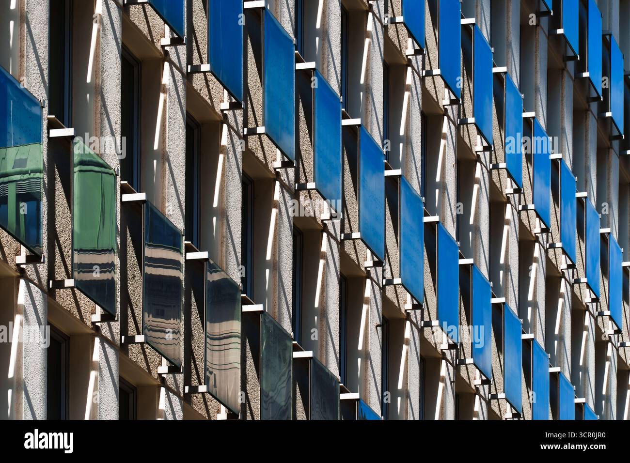Modern facade with angled blue glass panels creating dynamic ...