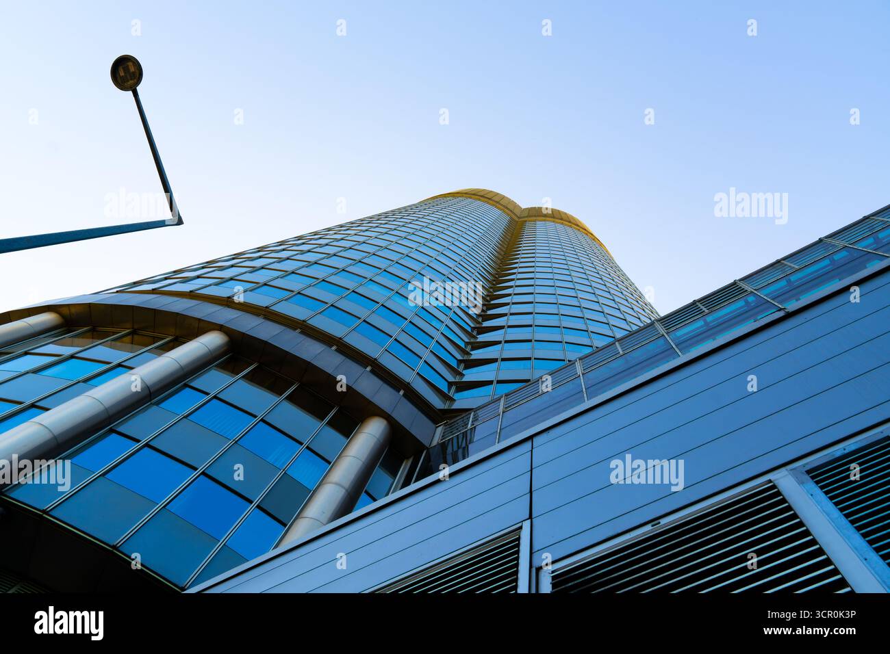 Modern curved office tower with glass grid facade rising against a ...