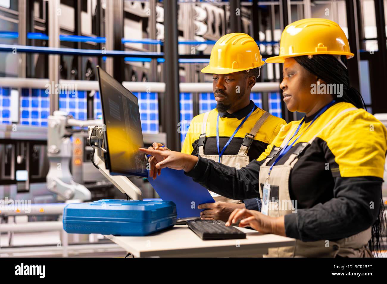 Engineering team oversee automated factory operations, using digital ...