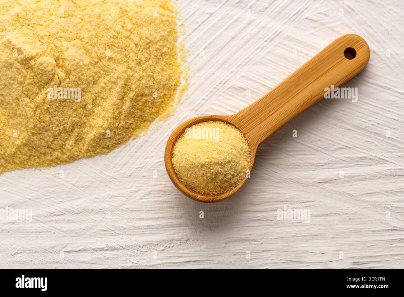 Coarse wheat semolina flour in a wooden spoon - Triticum Stock Photo ...