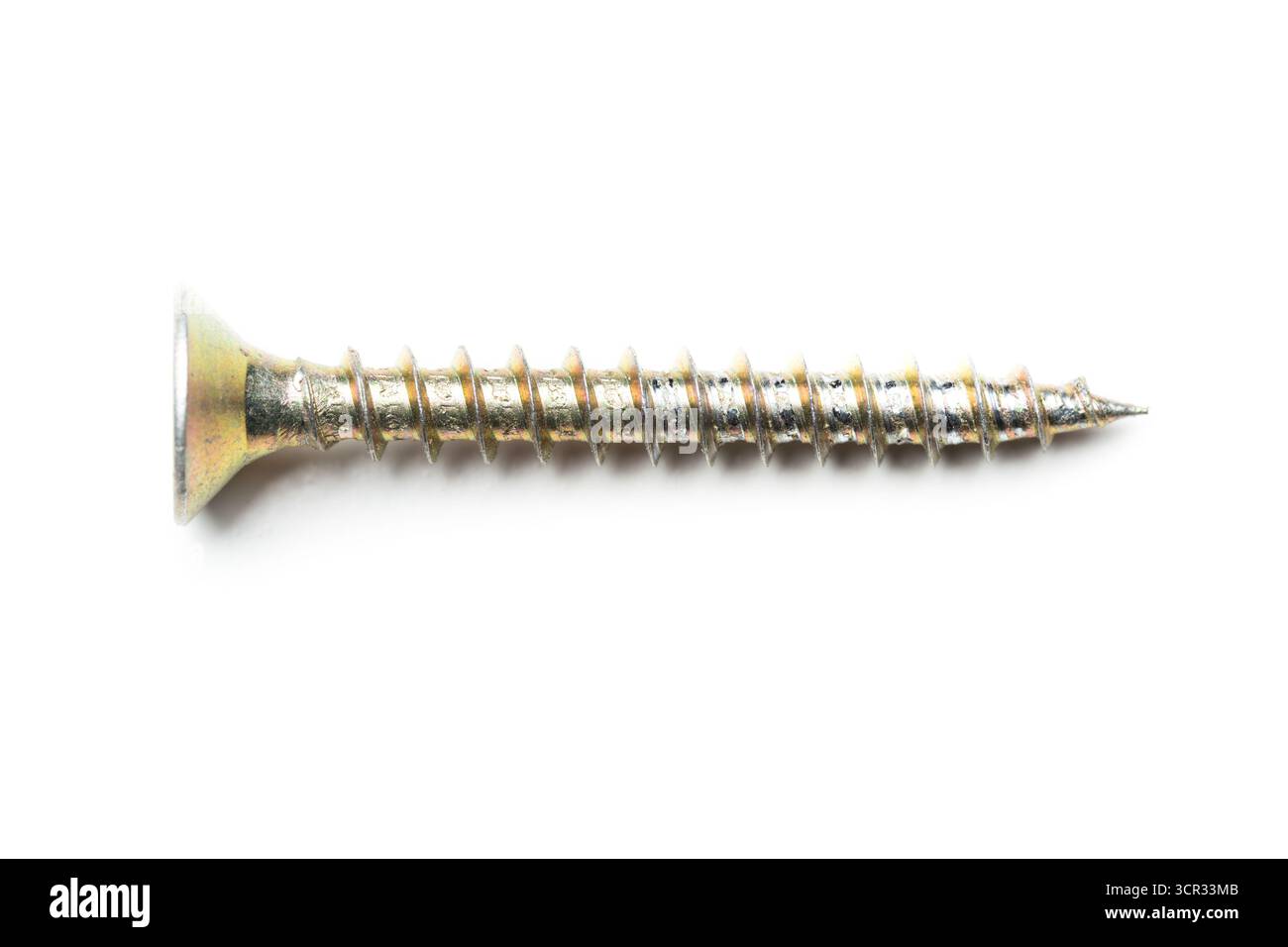 Small metal screw lying on a plain surface ready for use in various ...