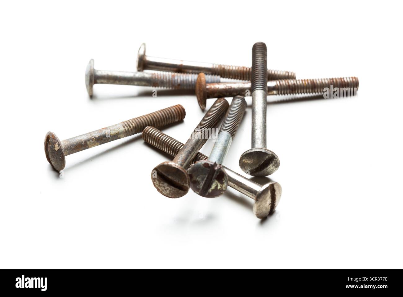 Various rusted screws scattered on a white surface ready for reuse or ...