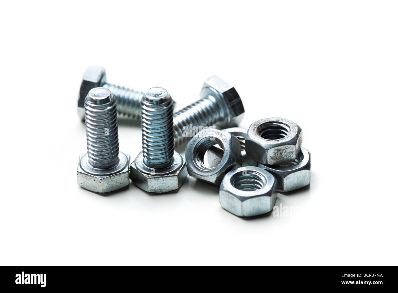 Assorted steel bolts and nuts arranged on a clean surface for ...