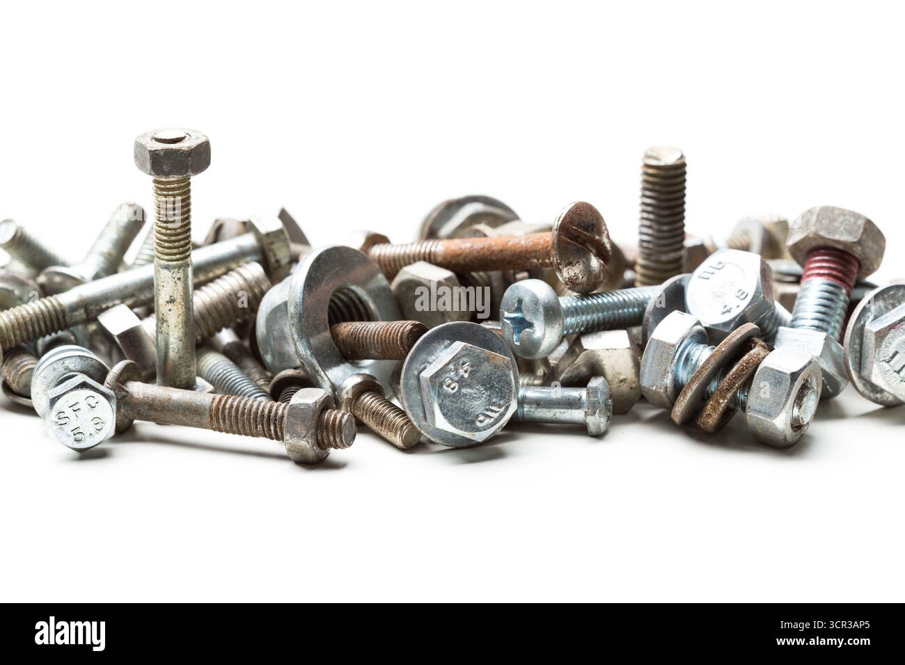 Assorted metal fasteners including nuts, bolts, and screws scattered on ...