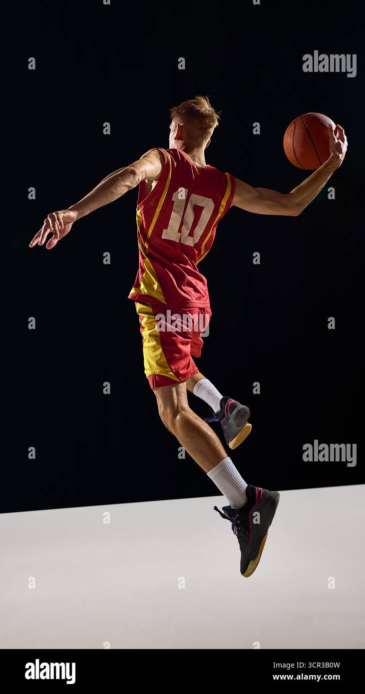 Basketball player number ten in red uniform preparing for slam dunk ...