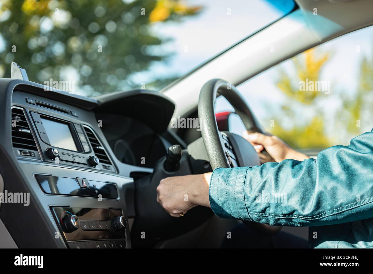 Female driver turning ignition key in right-hand drive car. Woman's ...