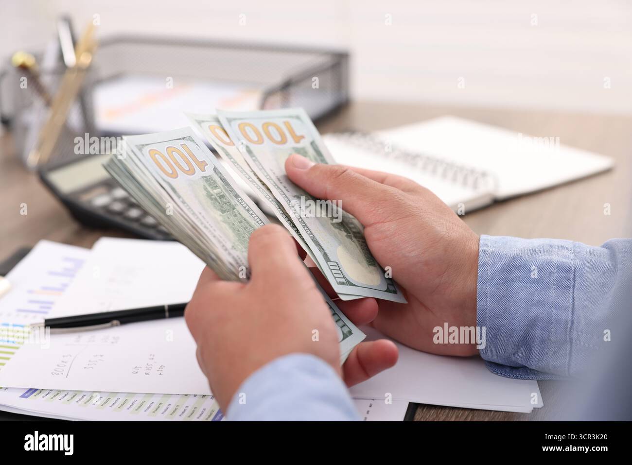 Man counting dollar banknotes at table, closeup Stock Photo - Alamy
