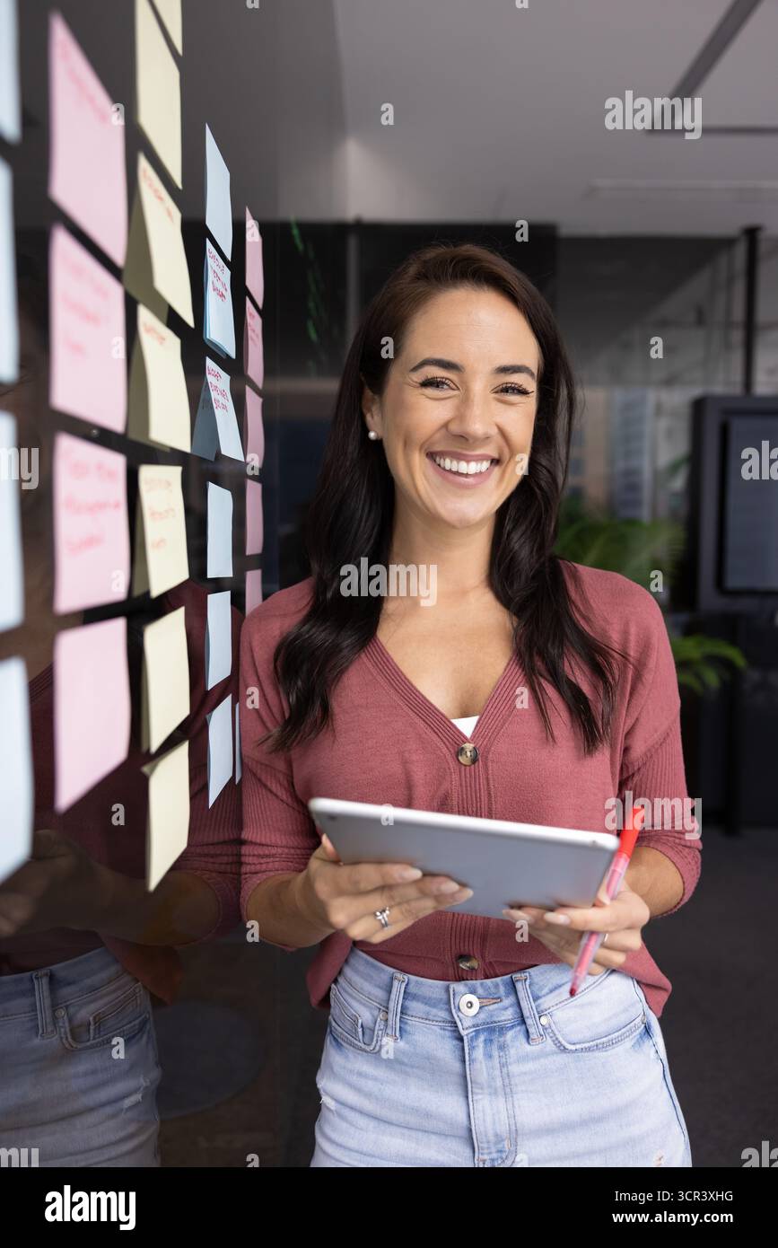 Project manager holds tablet, stand next to glass board, portrait Stock ...