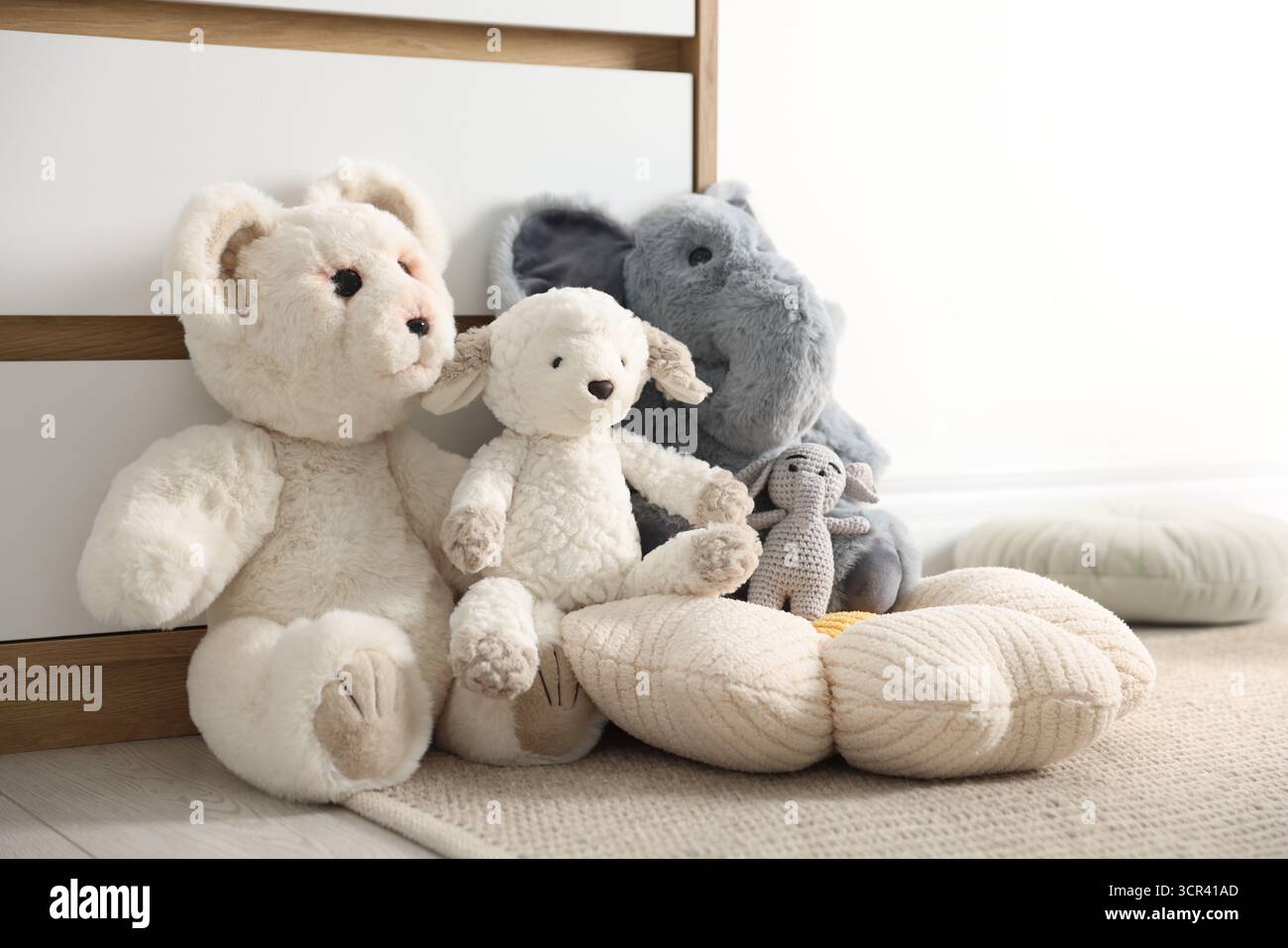 Different cute soft toys on floor indoors Stock Photo - Alamy