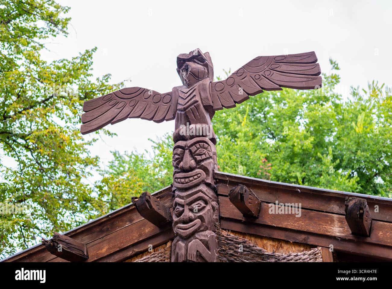 Handcrafted wooden totem pole featuring expressive carved faces and ...
