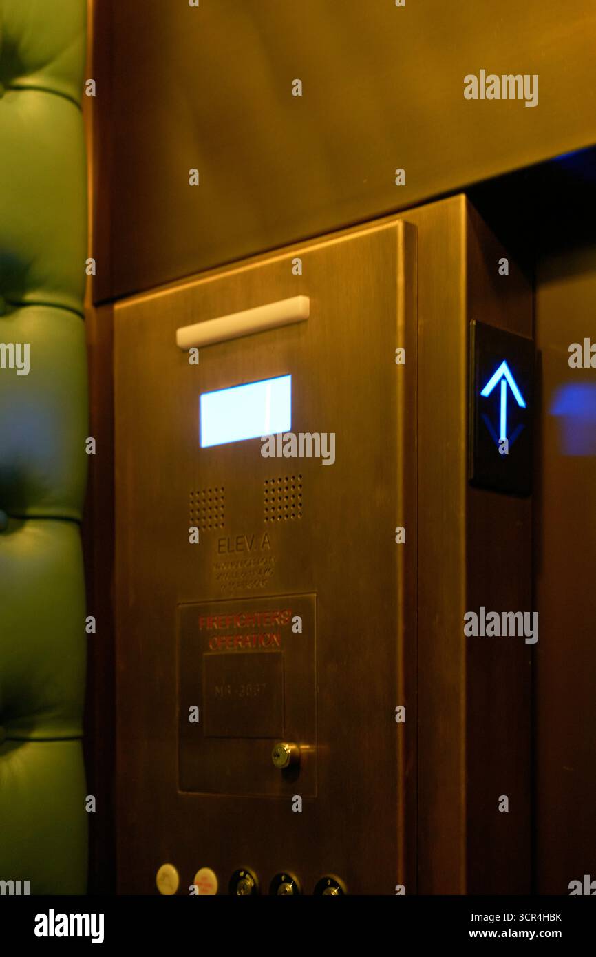 Elevator interior with green padded wall and glowing blue up arrow ...