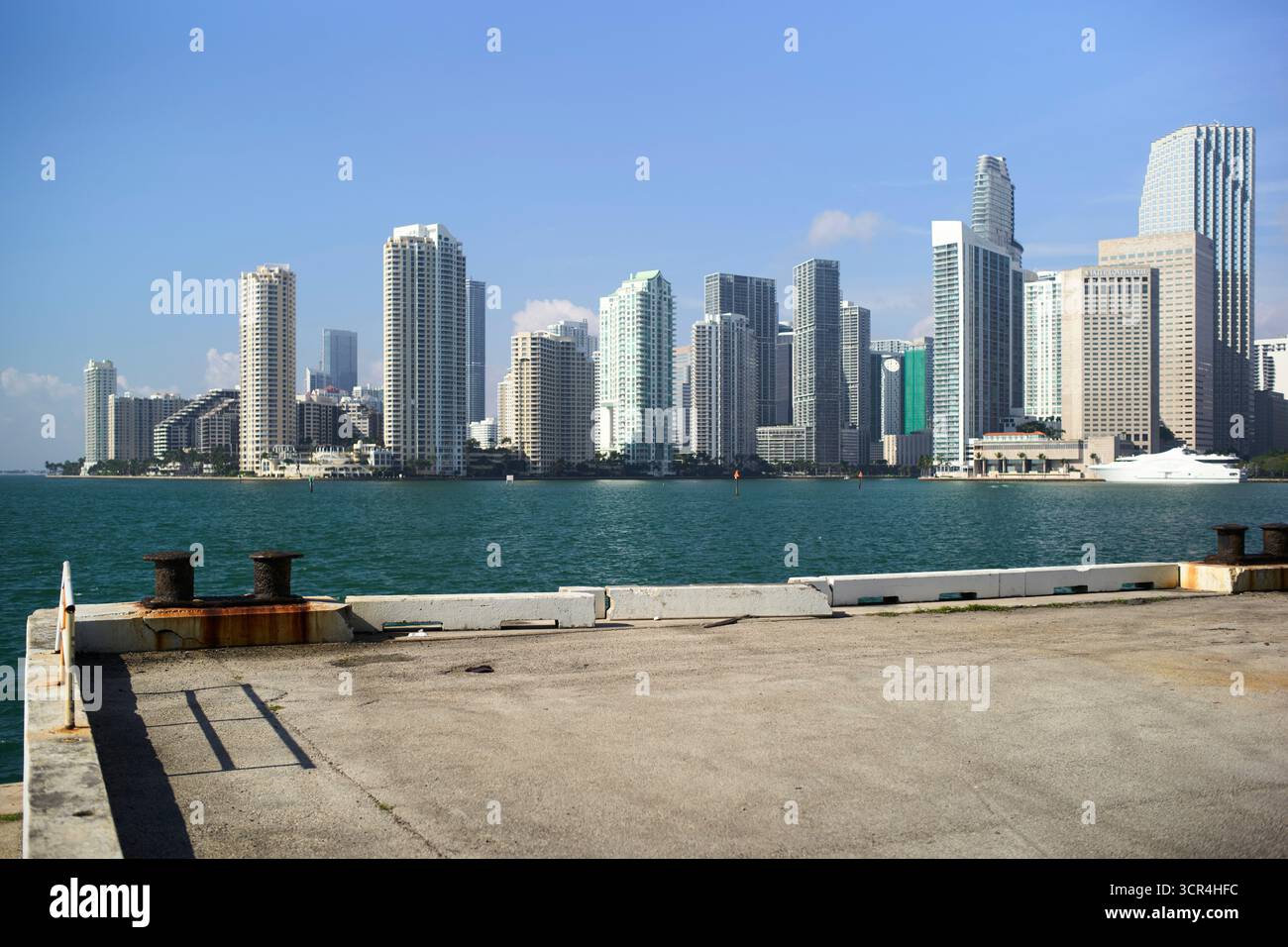 Skyline of modern skyscrapers near a waterfront under a clear blue sky ...