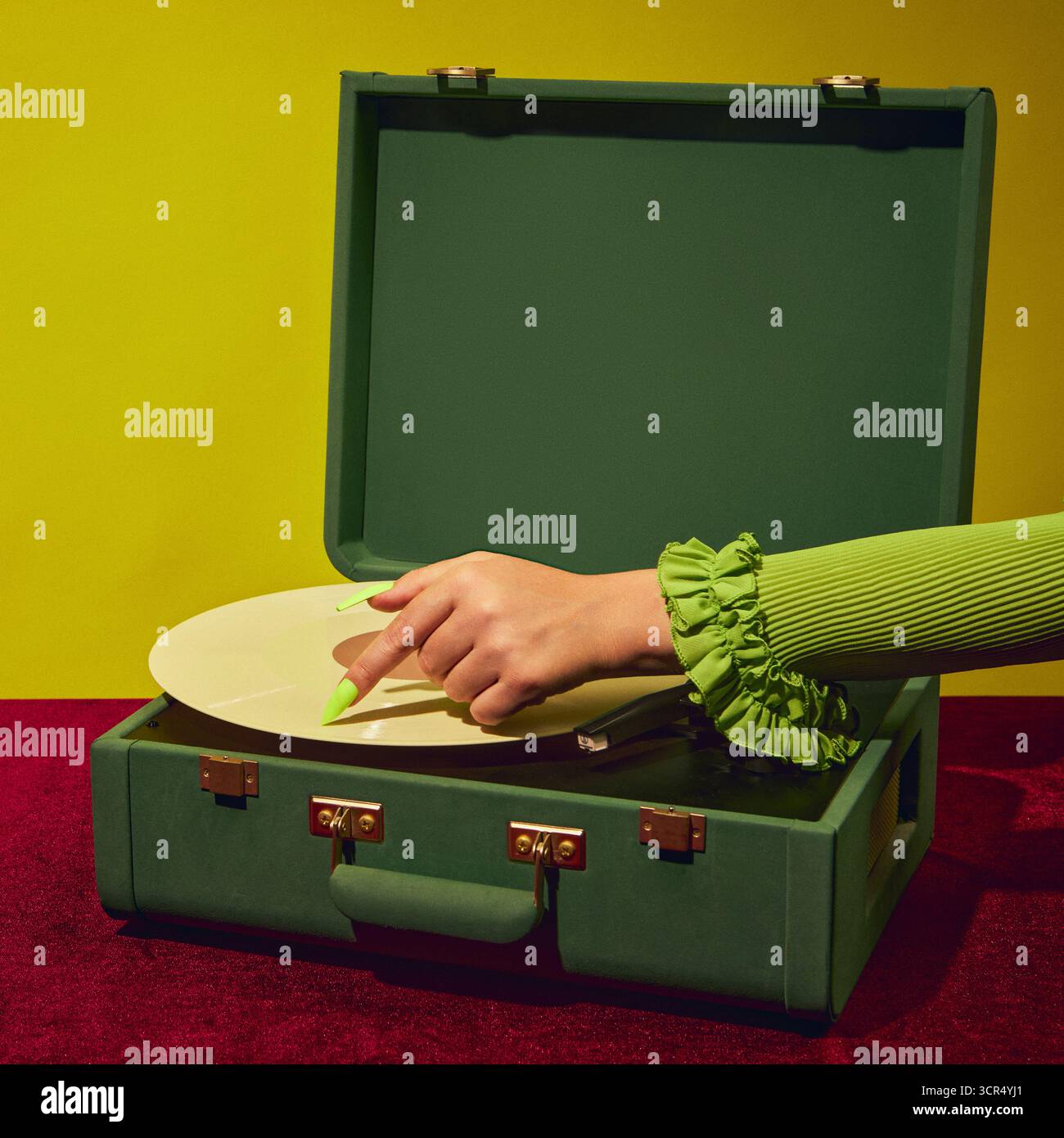 Hand with neon nails touching white vinyl record on retro turntable ...
