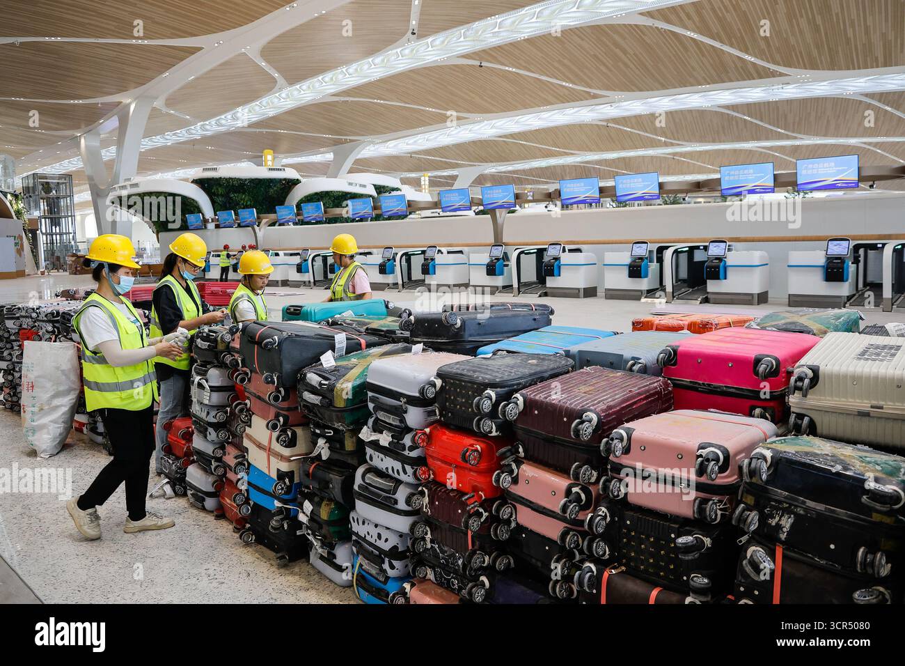 (250929) -- GUANGZHOU, Sept. 29, 2025 (Xinhua) -- Staff members carry out a check-in luggage ...