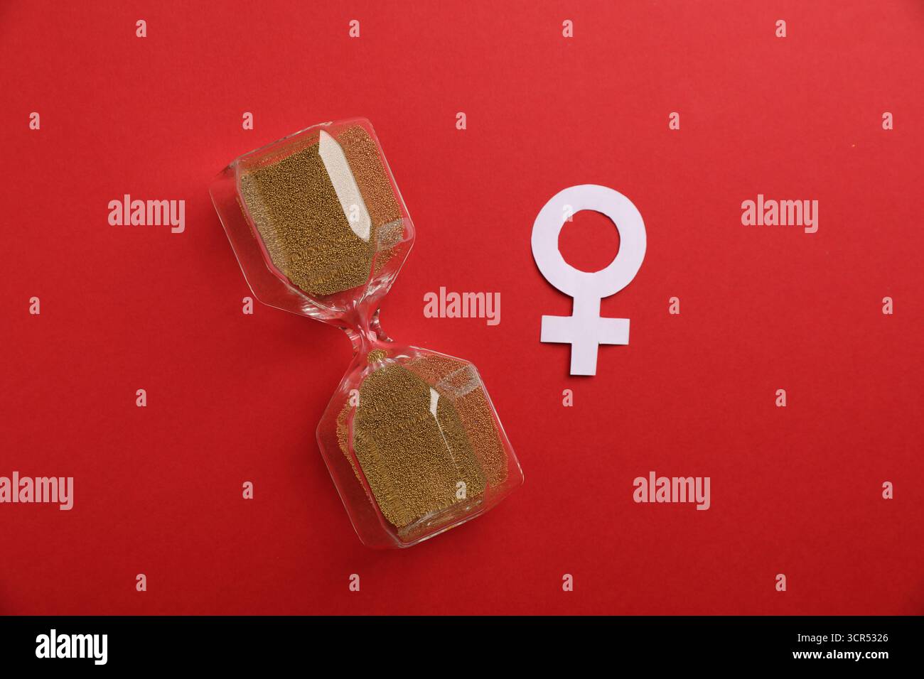 Menopause. Female gender symbol and hourglass on red background, top ...