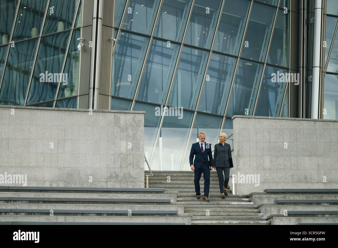 Middle aged Caucasian man and mature woman companion walking down ...