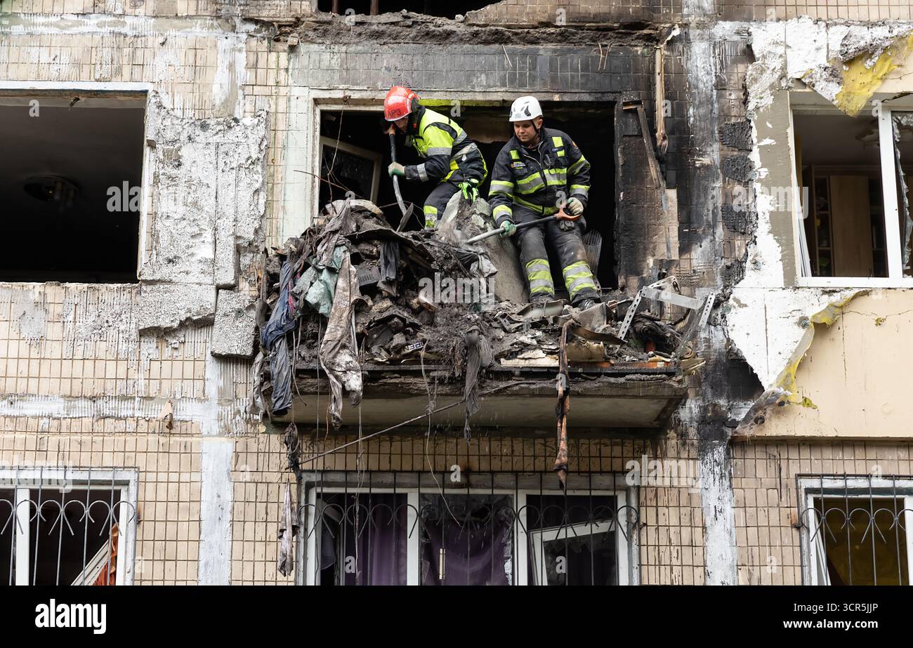 Two rescuers in protective gear and helmets are seen working on a ...