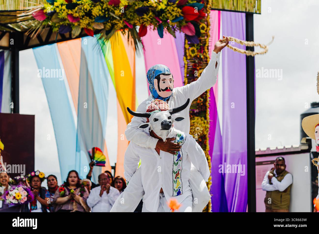 Two dancers in white costumes, one with a bull mask and the other with ...
