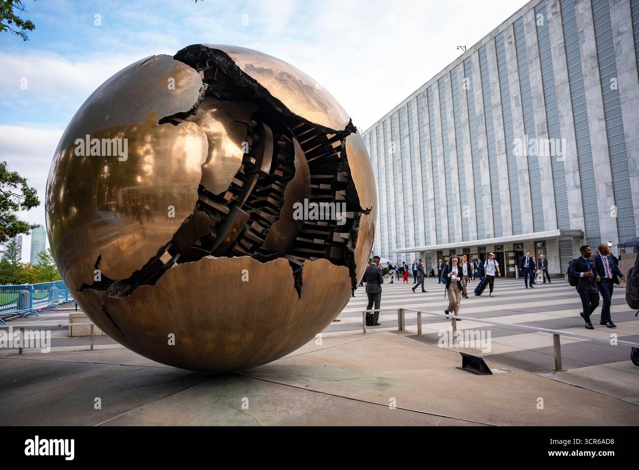 FILE - People walk around the plaza by the Sphere Within Sphere outside ...
